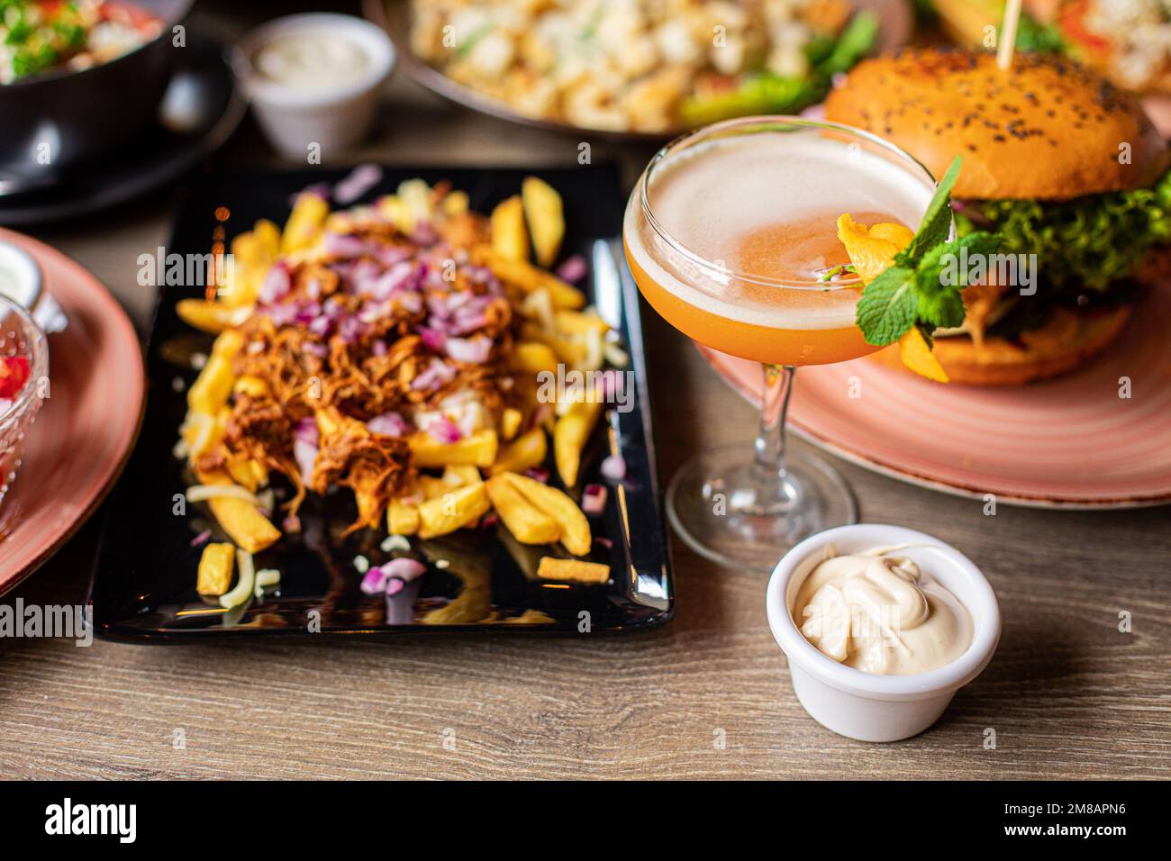Close-up of yummy dish from French fries and cut red onion on black ...