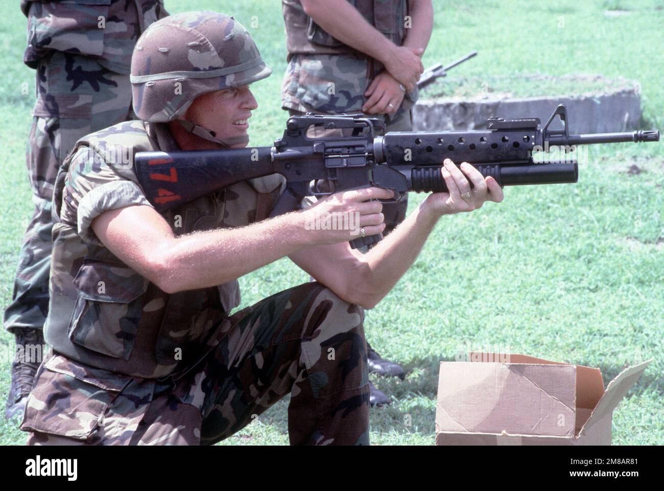 A Marine prepares to fire the 40 mm M203 grenade launcher attached to ...