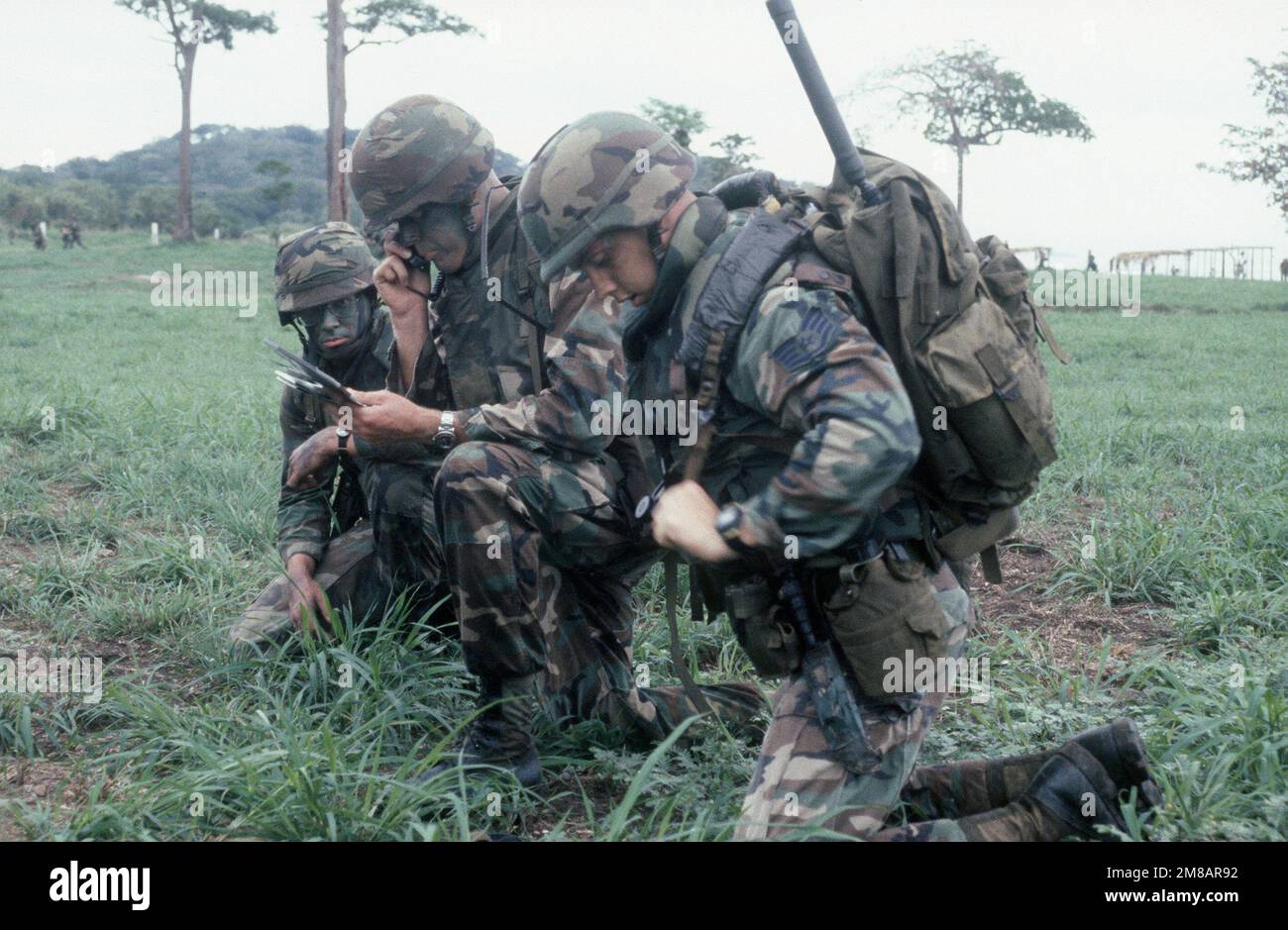 An Air Force radio operator adjusts his pack straps as he pauses with ...