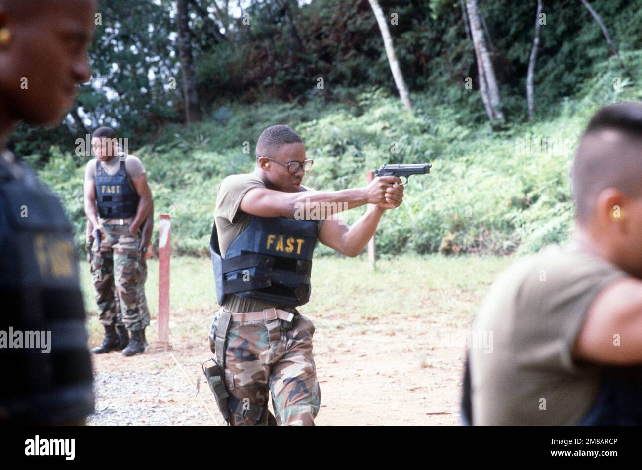 A Marine with M9 9 mm pistol engages a target on a combat pistol course. He is a member of 4th ...