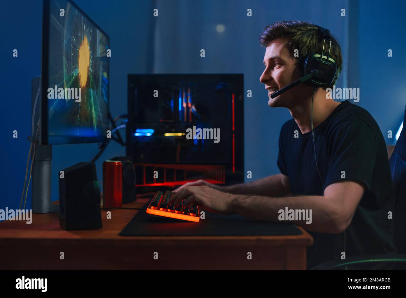 Young handsome pro gamer playing in online video game on computer at ...