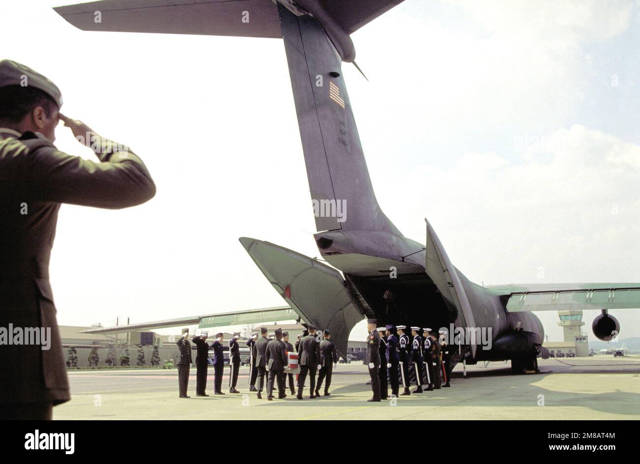 Pallbearers carrying a flag-draped coffin pass between the American and ...