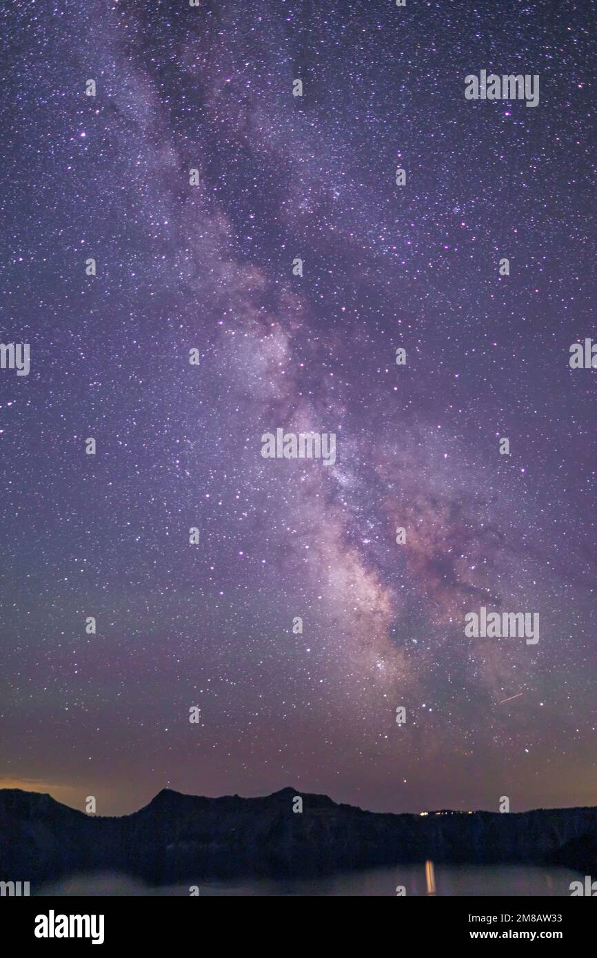 A vertical shot of a starry sky over Crater lake in Oregon, United ...