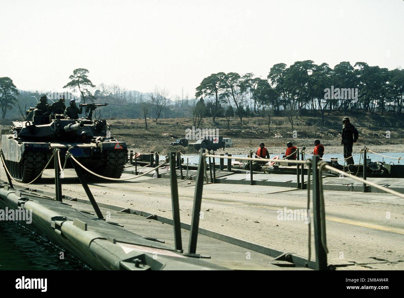 Soldiers drive an M-1 Abrams tank across a portable bridge during ...
