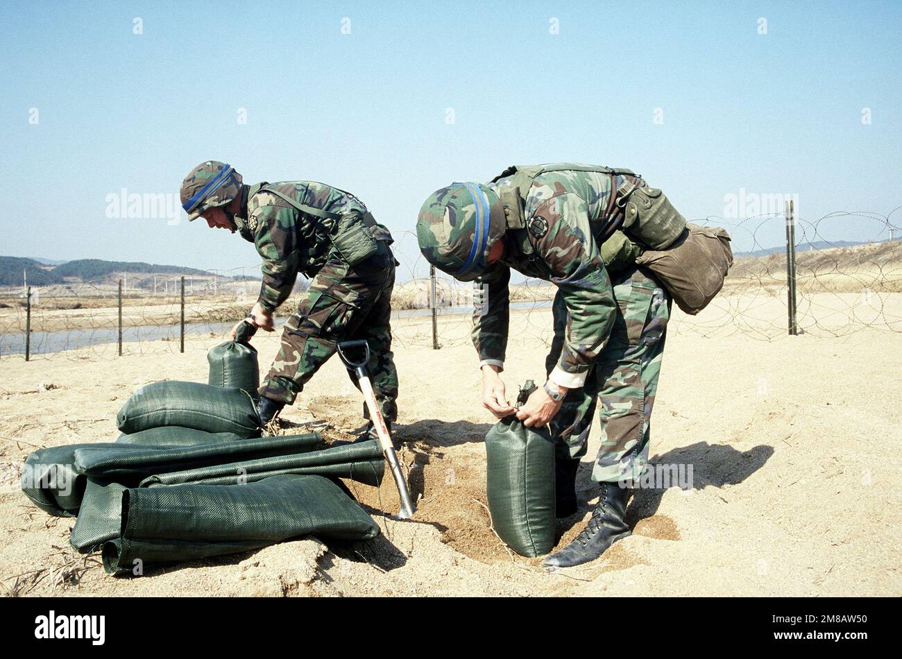 Two soldiers fill sandbags at the beginning of exercise Team Spirit '89 ...
