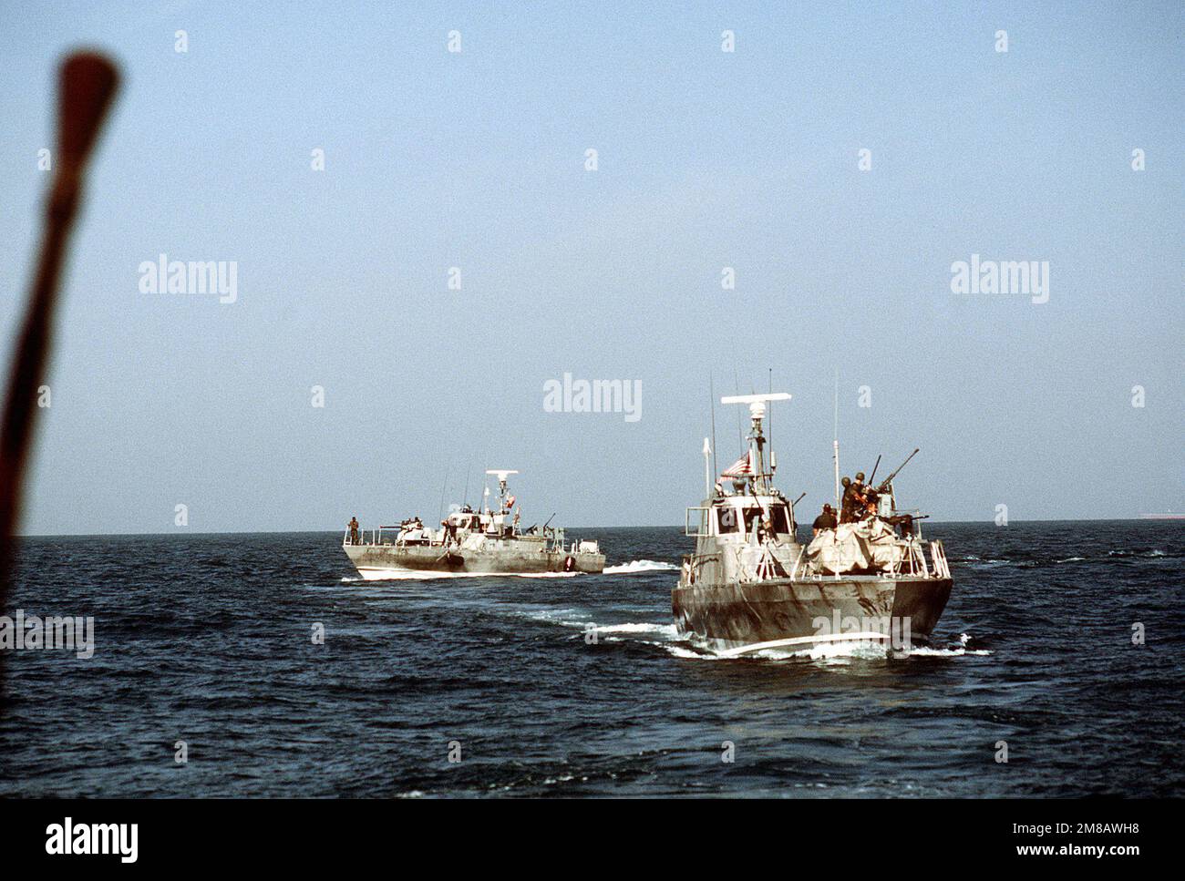 Crewmen stand ready at the guns of two PB Mark III patrol boats ...