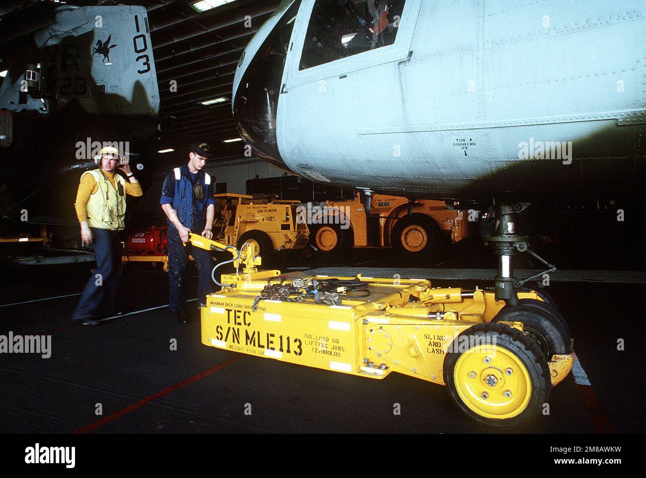 Crewmen use an aircraft spotting dolly to move a Marine Medium Helicopter Squadron 161 (HMM-161 ...