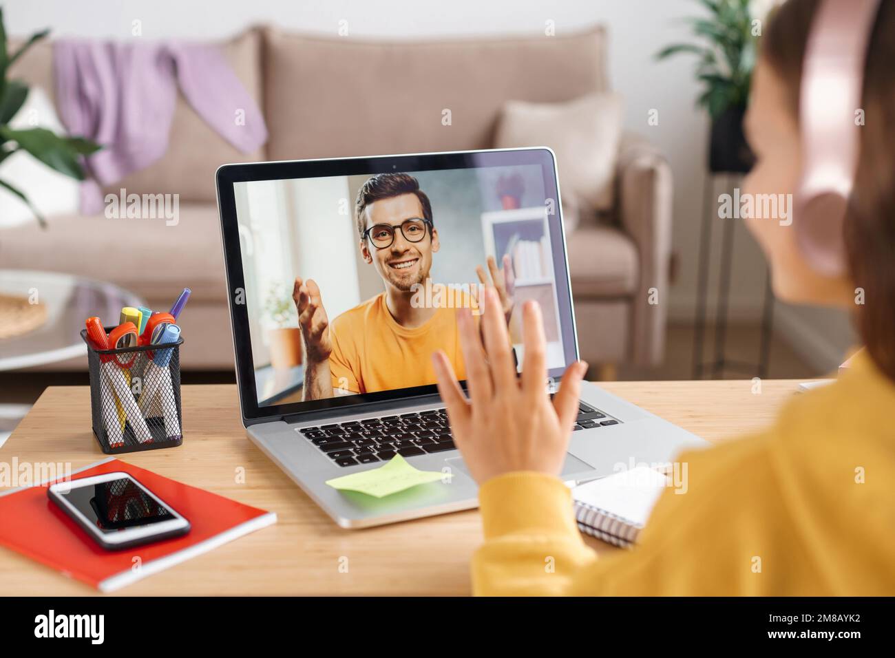 Little girl using headphones and laptop for learning online class from ...