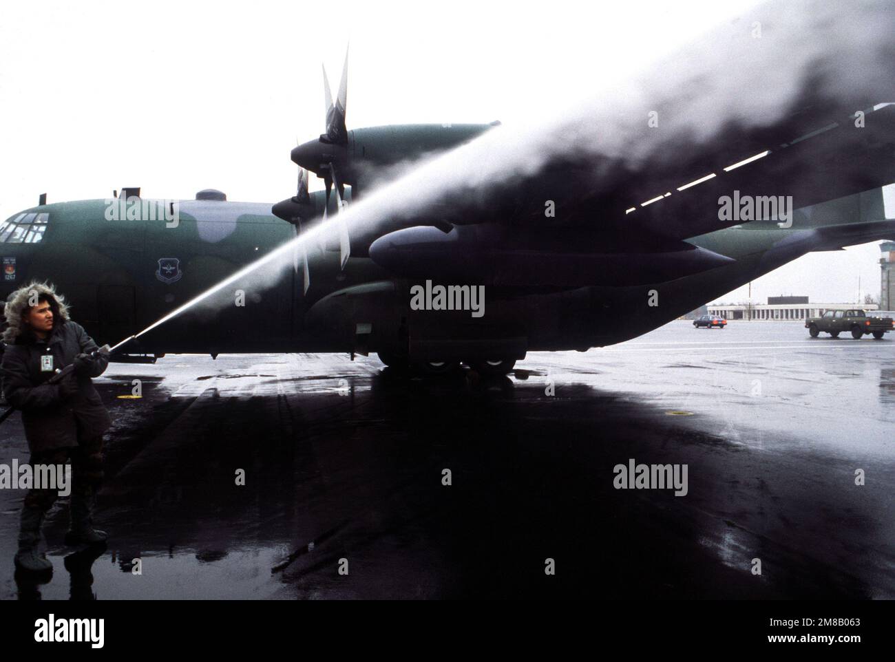 A member of the 20th Special Operations Squadron hoses down an MC-130 ...