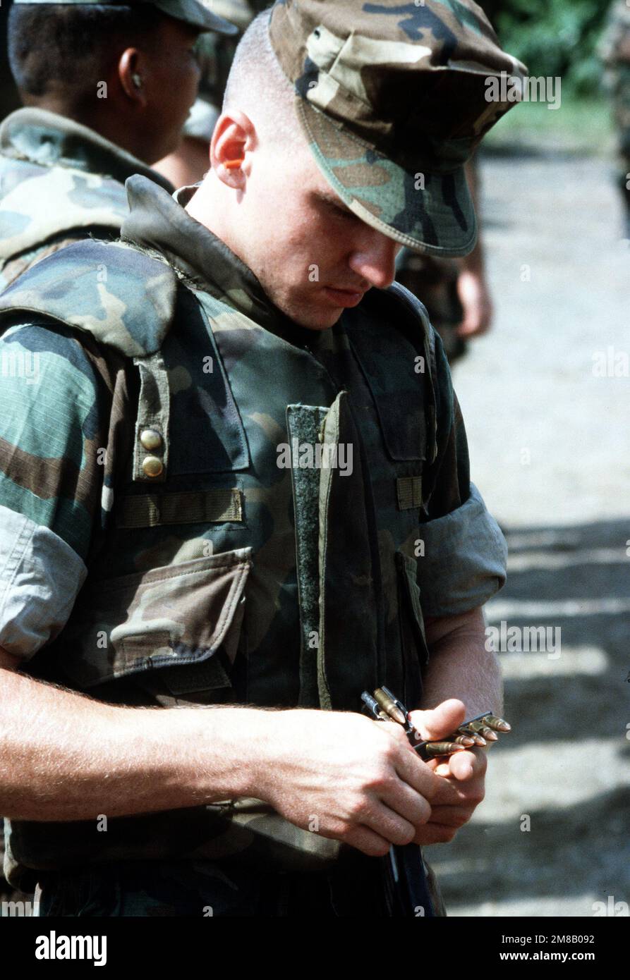 A Marine loads ammunition into a magazine prior to a weapons ...