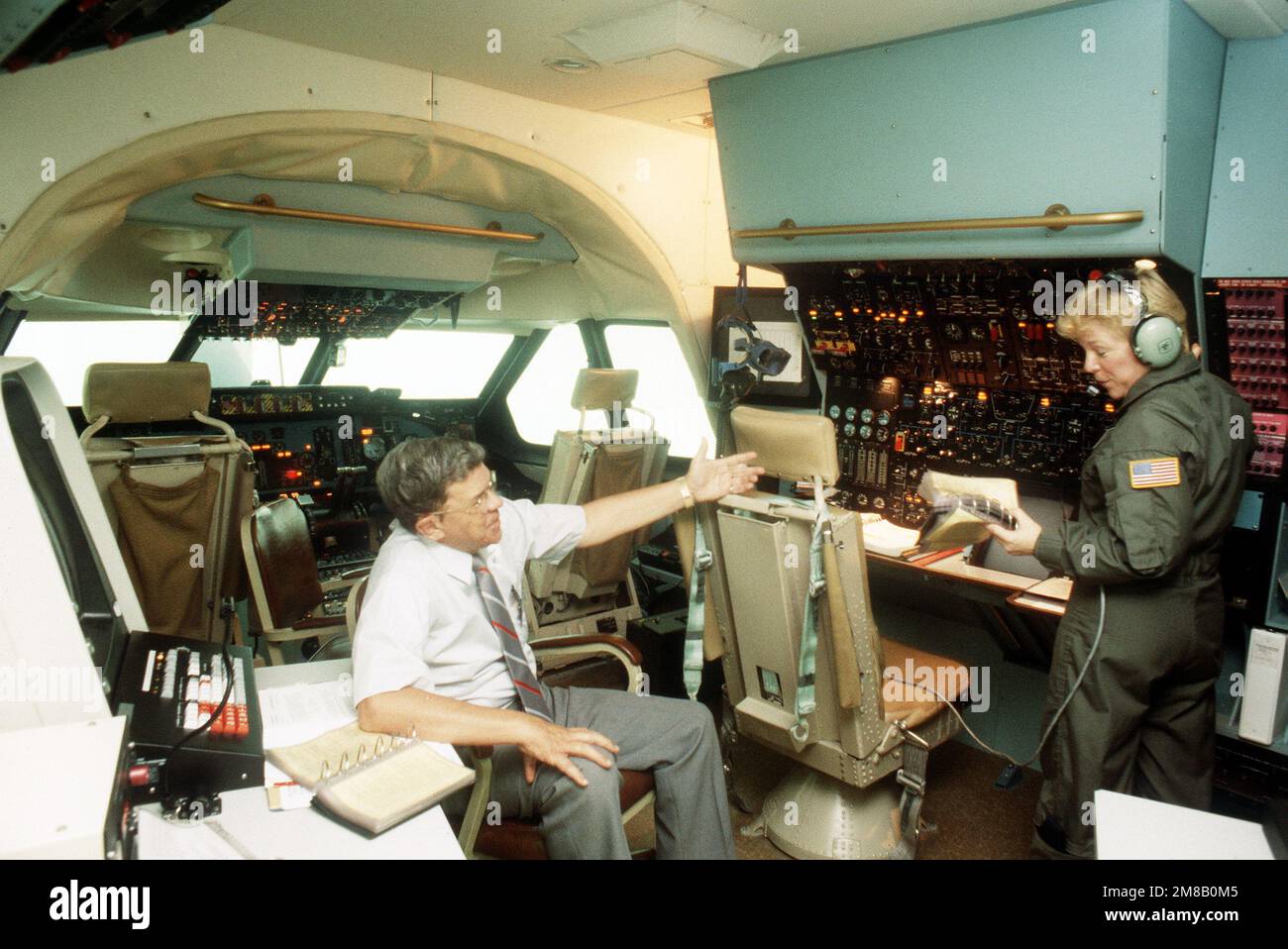 A civilian employee and an air crewman check the instrument panel in a ...