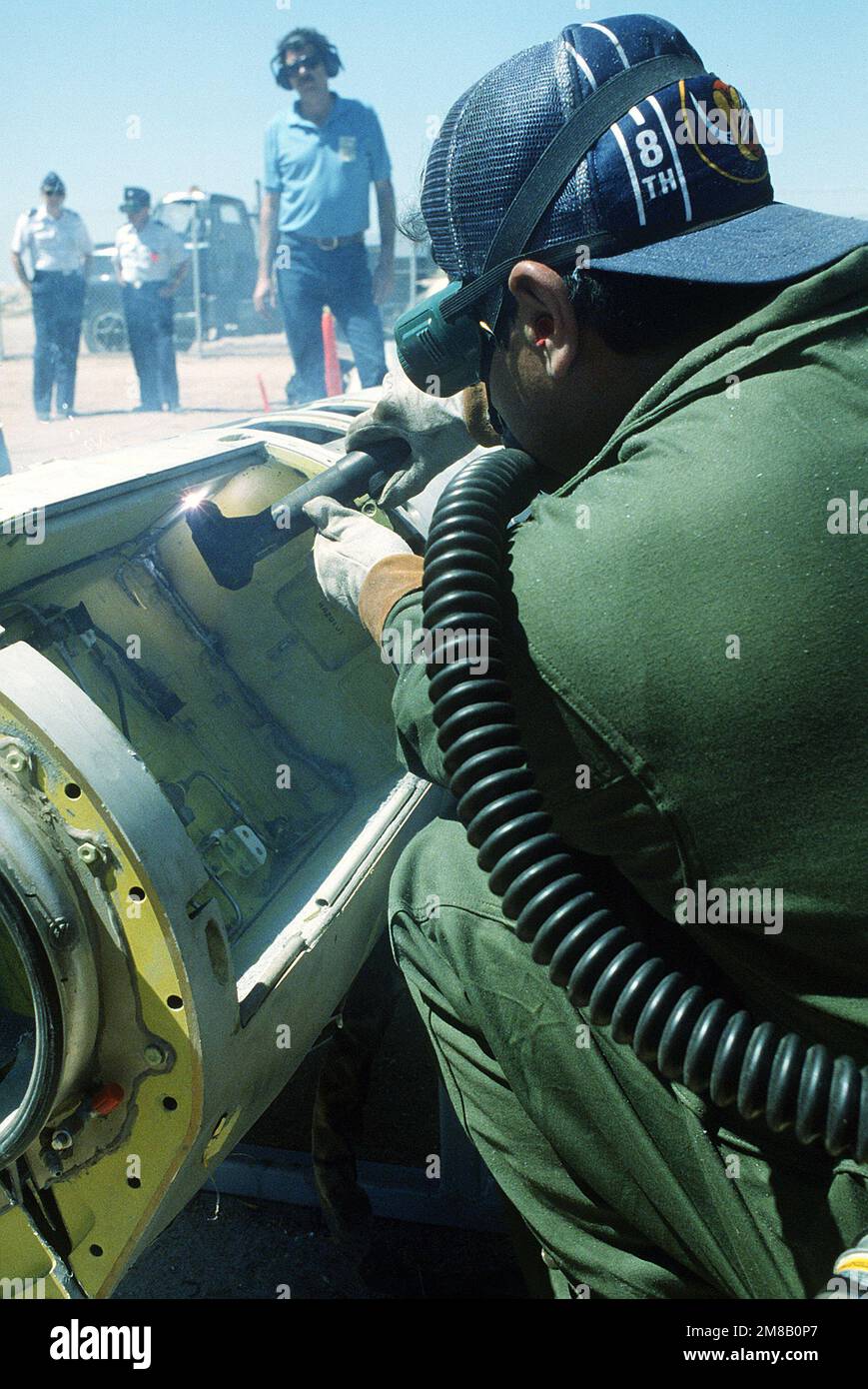 A civilian employee uses a plasma-arc welders to cut through a section ...