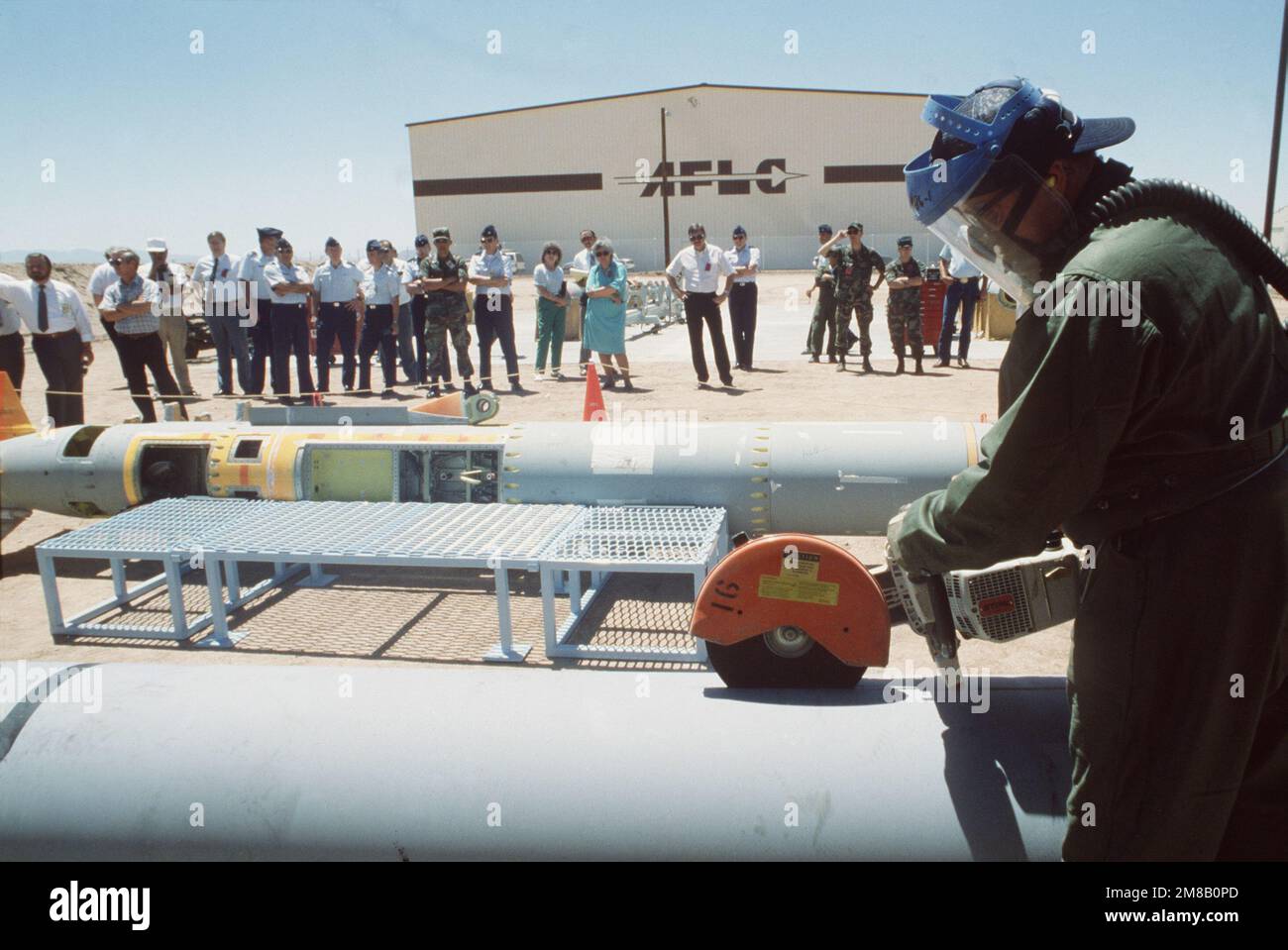 A civilian employee uses a specially-developed saw to cut through a ...