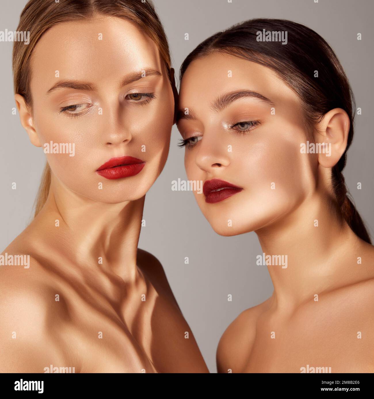 Aesthetics of beauty. Portrait of two young, beautiful girls with red ...
