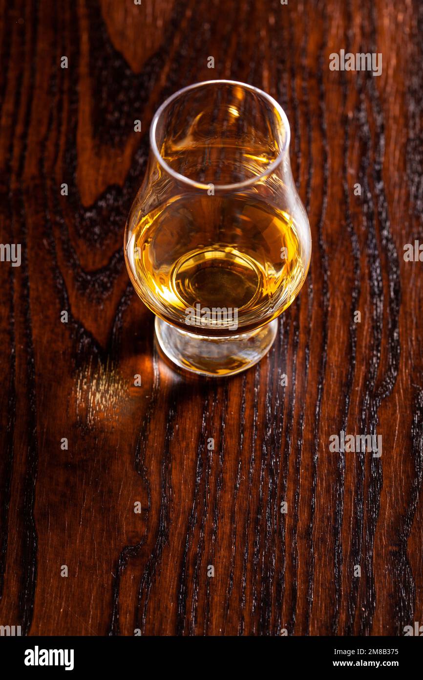 glass of whisky spirit brandy on dark brown background Stock Photo - Alamy