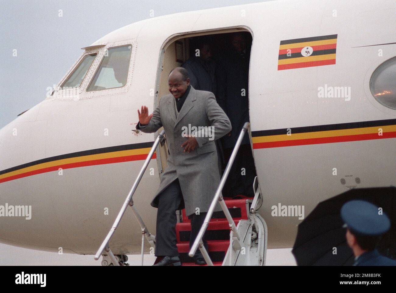 H. E. Yoweri Museveni, President of Uganda, waves as he disembarks from ...