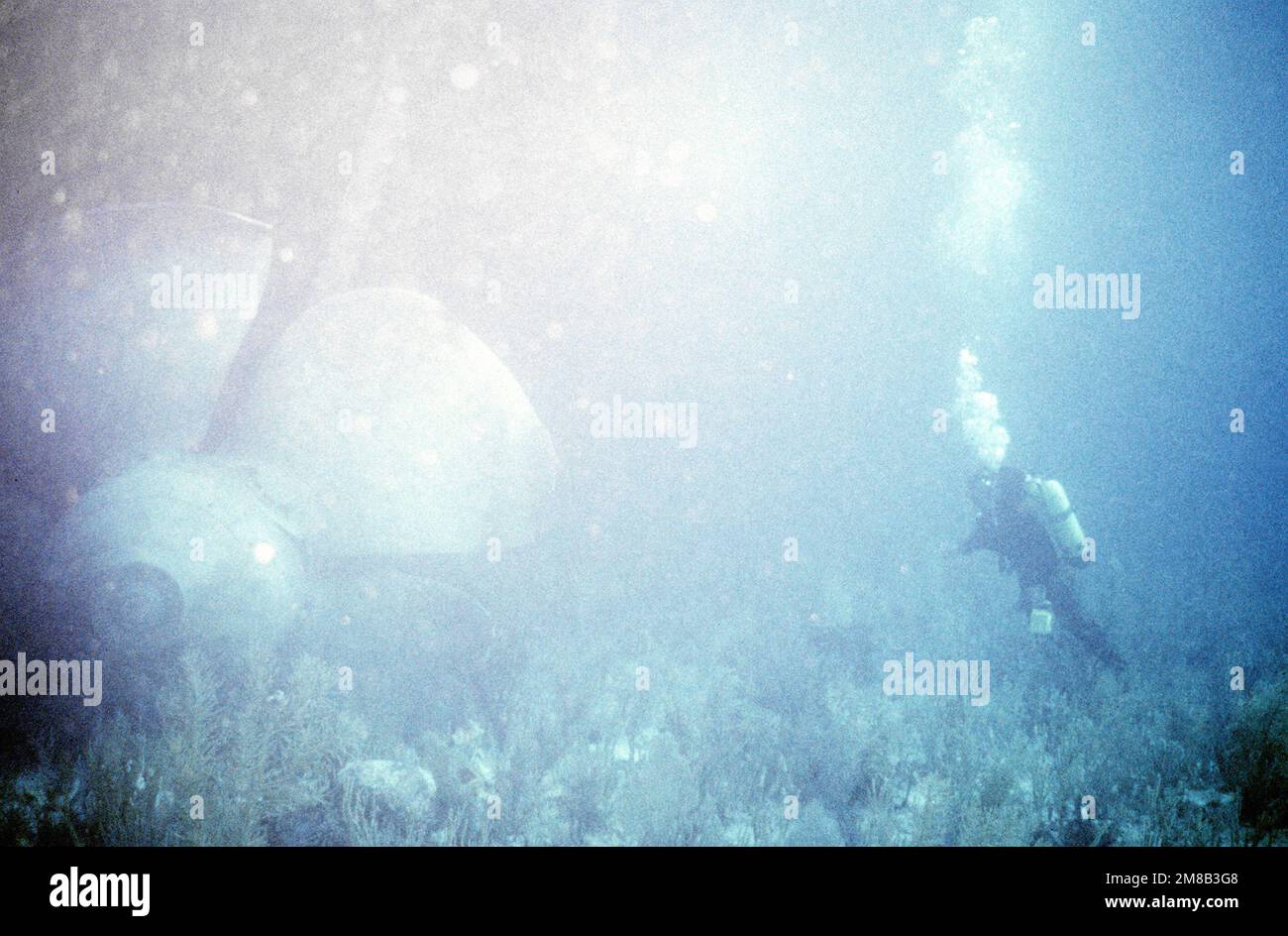 A diver from the salvage ship USS GRASP (ARS-51) inspects one of the ...