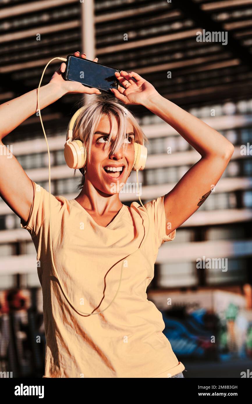 Woman enjoying listening to music with headphones and mobile phone ...