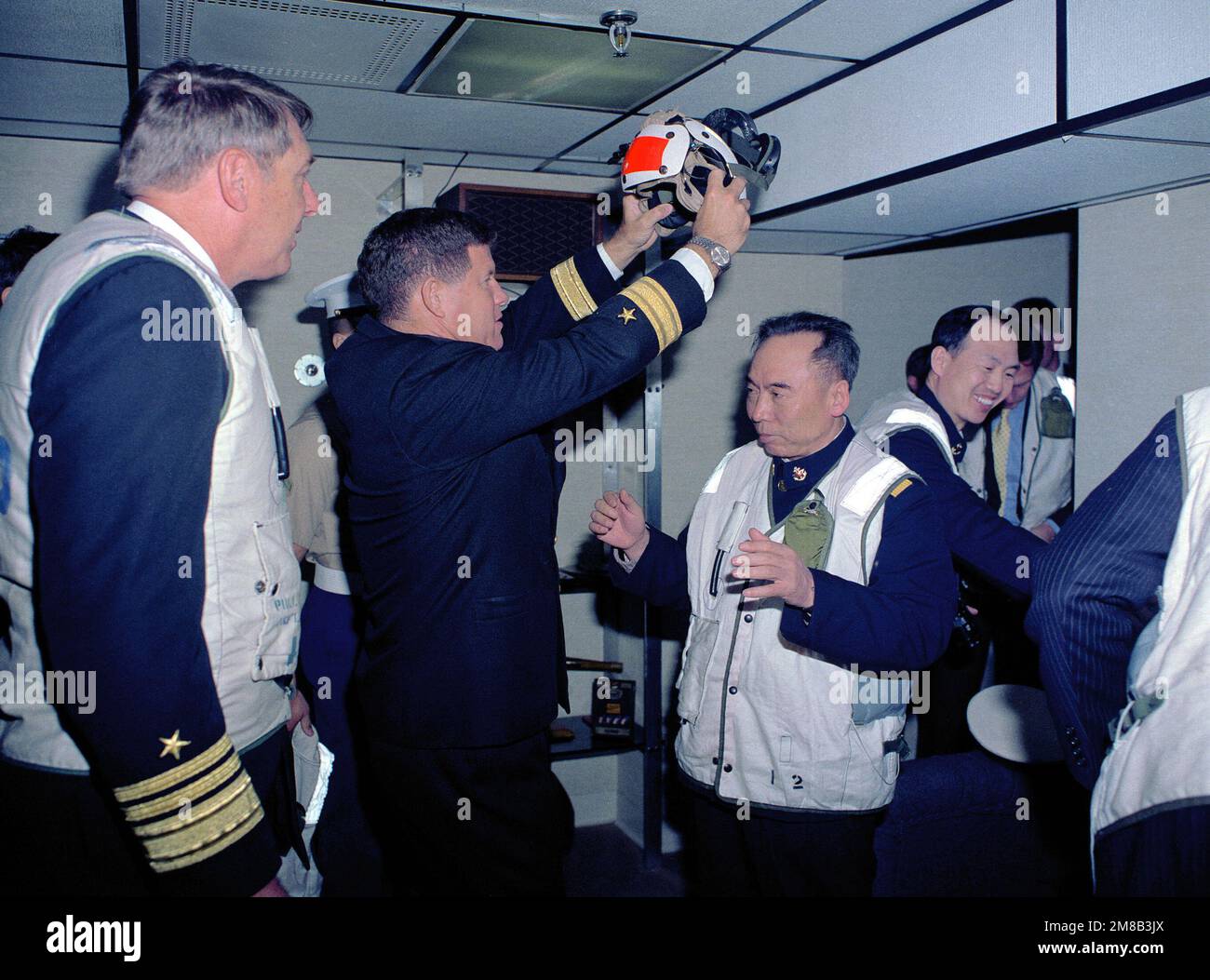 RDML (lower half) Thomas A. Mercer, commander, Carrier Group 7, assists ...
