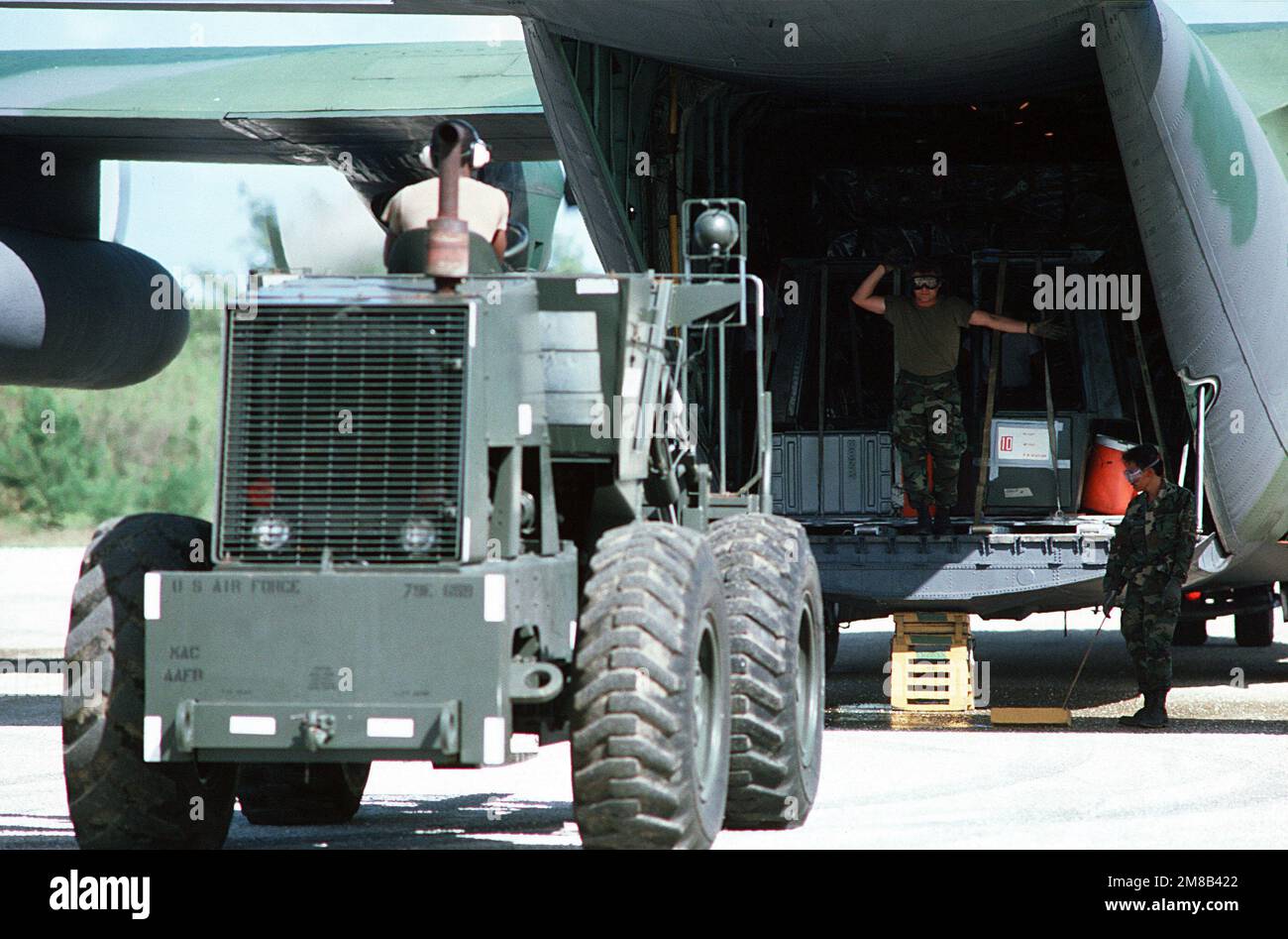 An airman guides the driver of an MW-20BFL forklift to the ramp of an ...