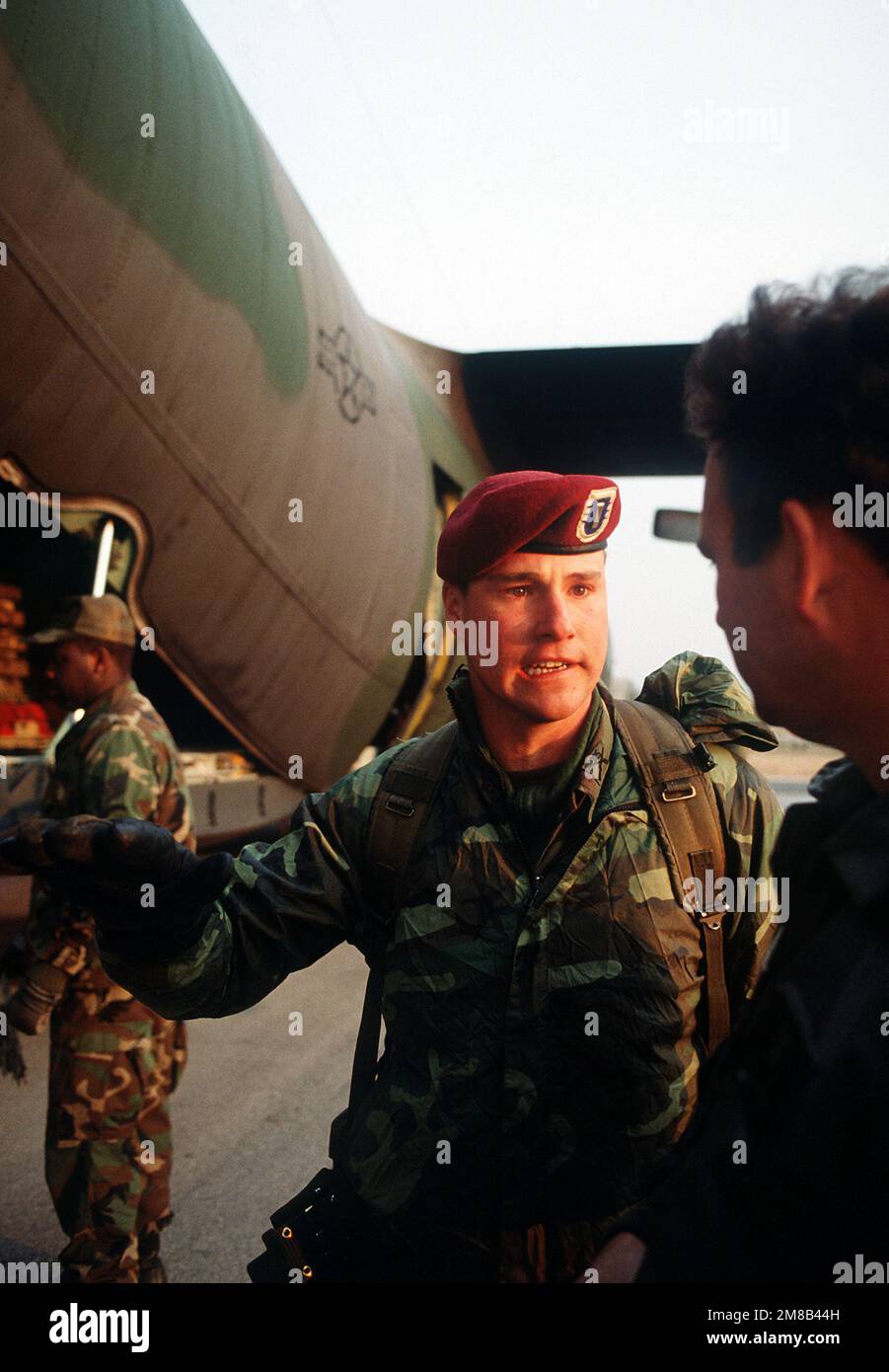Air Force personnal confer during the loading of a C-130E Hercules ...