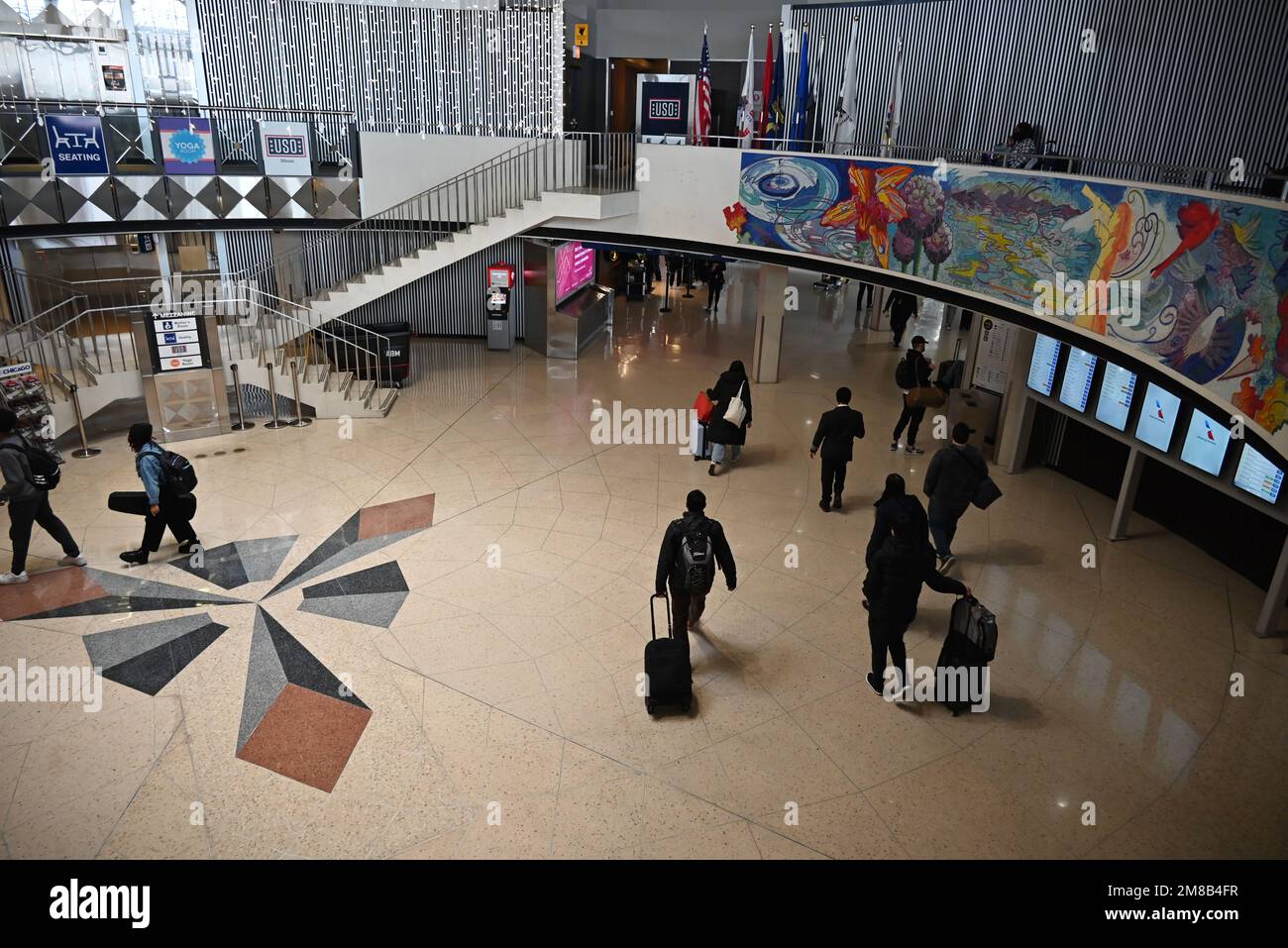 Travelers pass through O'Hare Airport's Rotunda Building as they ...