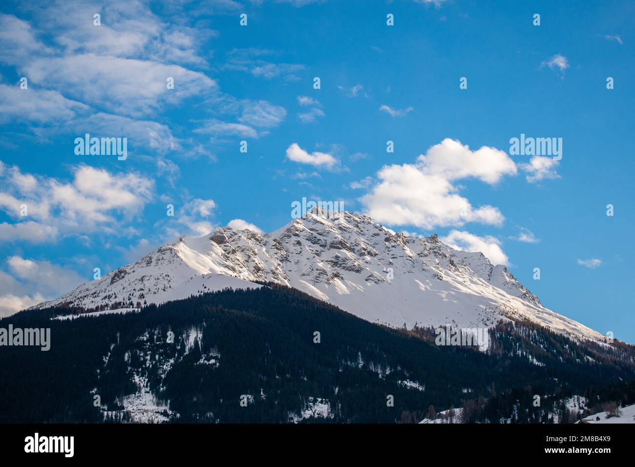 A snow-covered mountain with a blue sky in the background Stock Photo ...