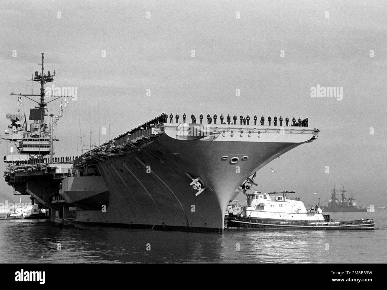 Tug boats assist the aircraft carrier USS RANGER (CV 61) as the ship ...