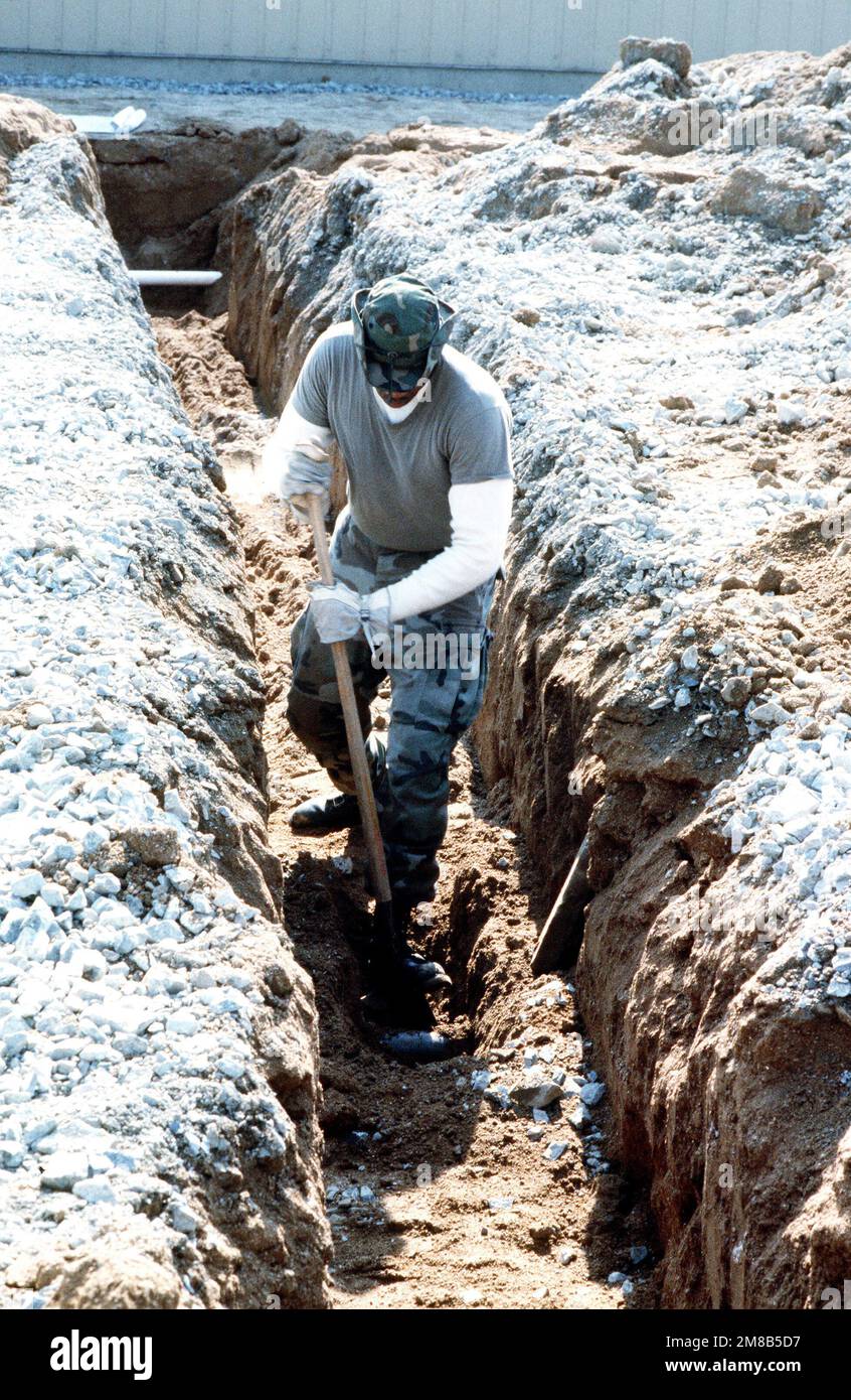 A member of a Prime Beef construction team digs a trench for a Harvest ...