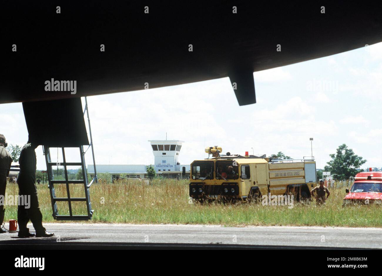 A fire truck stands by at the arrival of a 60th Military Airlift Wing C ...