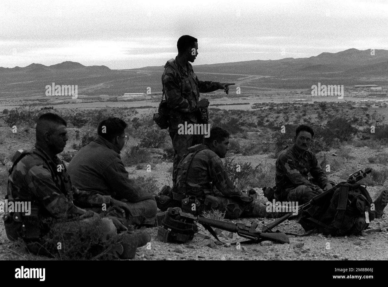 Five soldiers takes a break after a day-long defensive exercise during ...