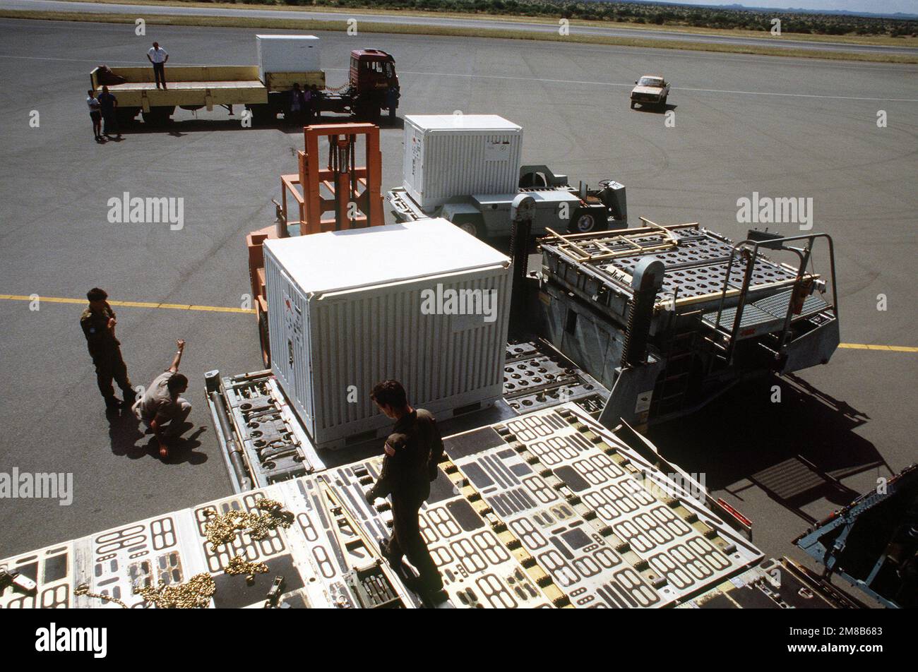 A forklift is used to move a container off of the front cargo ramp of a ...