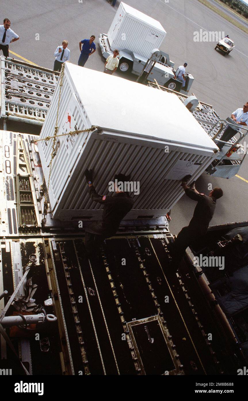 Two flight crewmen push a container off of a 60th Military Airlift Wing ...