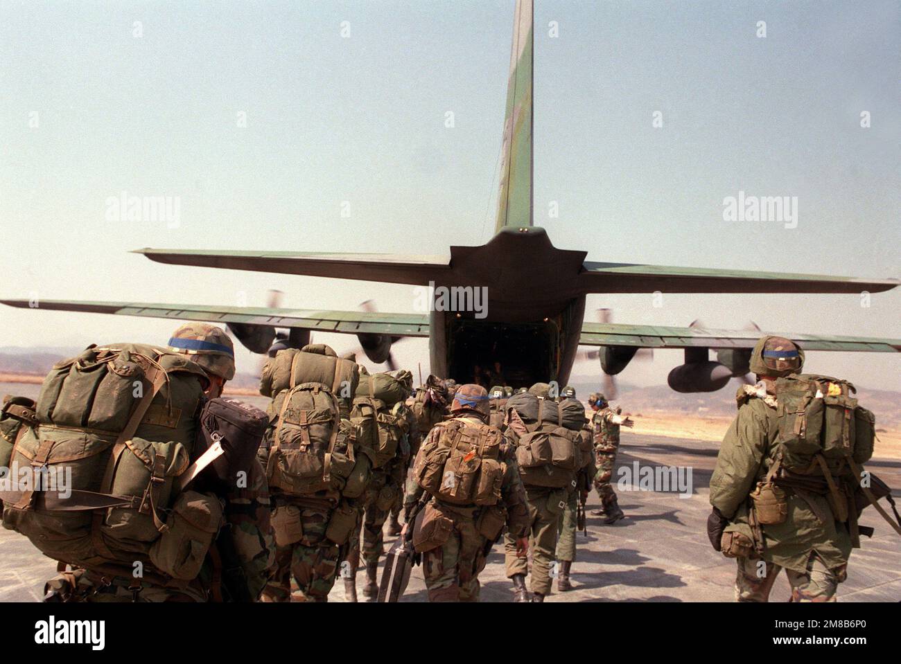 Members of Co. C, 3rd Bn., 22nd Inf., 25th Inf. Div. (Light), board a C-130 Hercules aircraft ...
