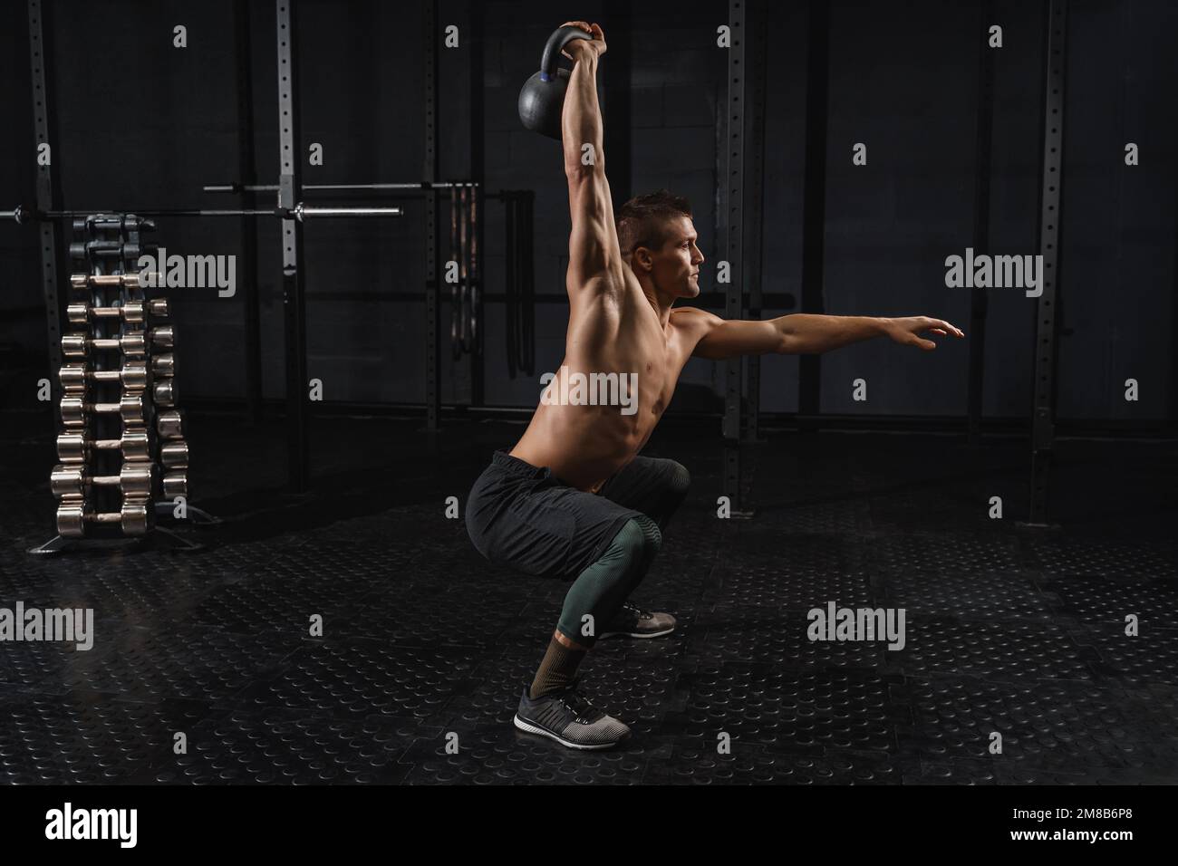 Cross fit training in a gym. Kettlebells swing exercise man workout at ...