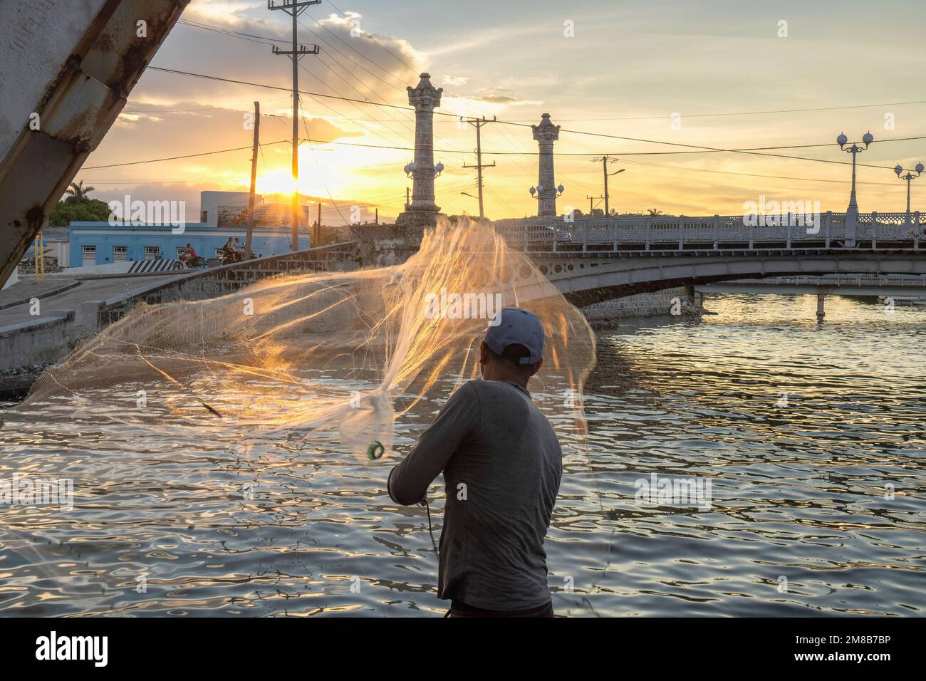 A Fisherman throwing fishing net during sunrise Stock Photo - Alamy