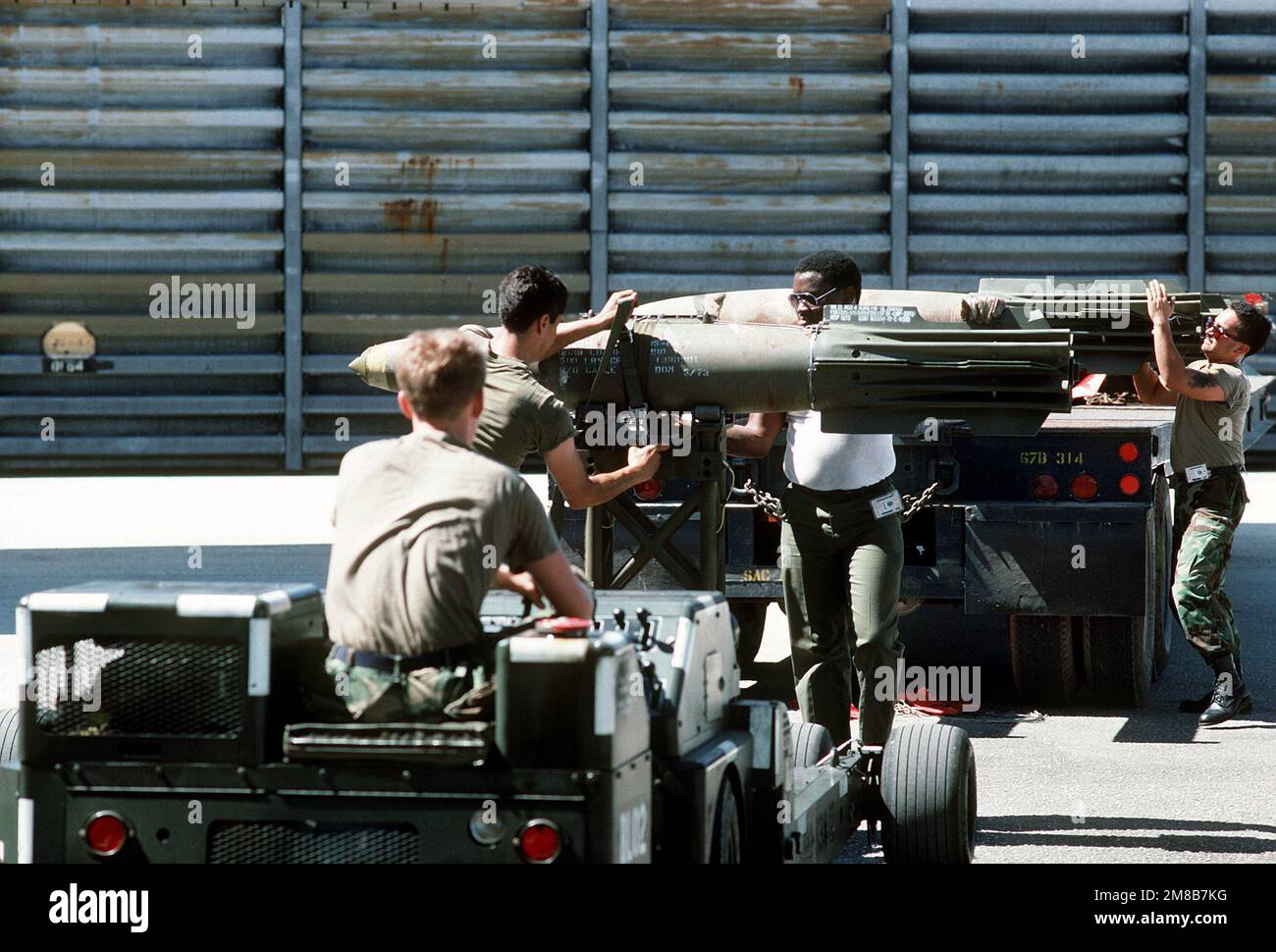 Members of the 43rd Bomb Wing's munitions loading team secure a Mark 82 ...