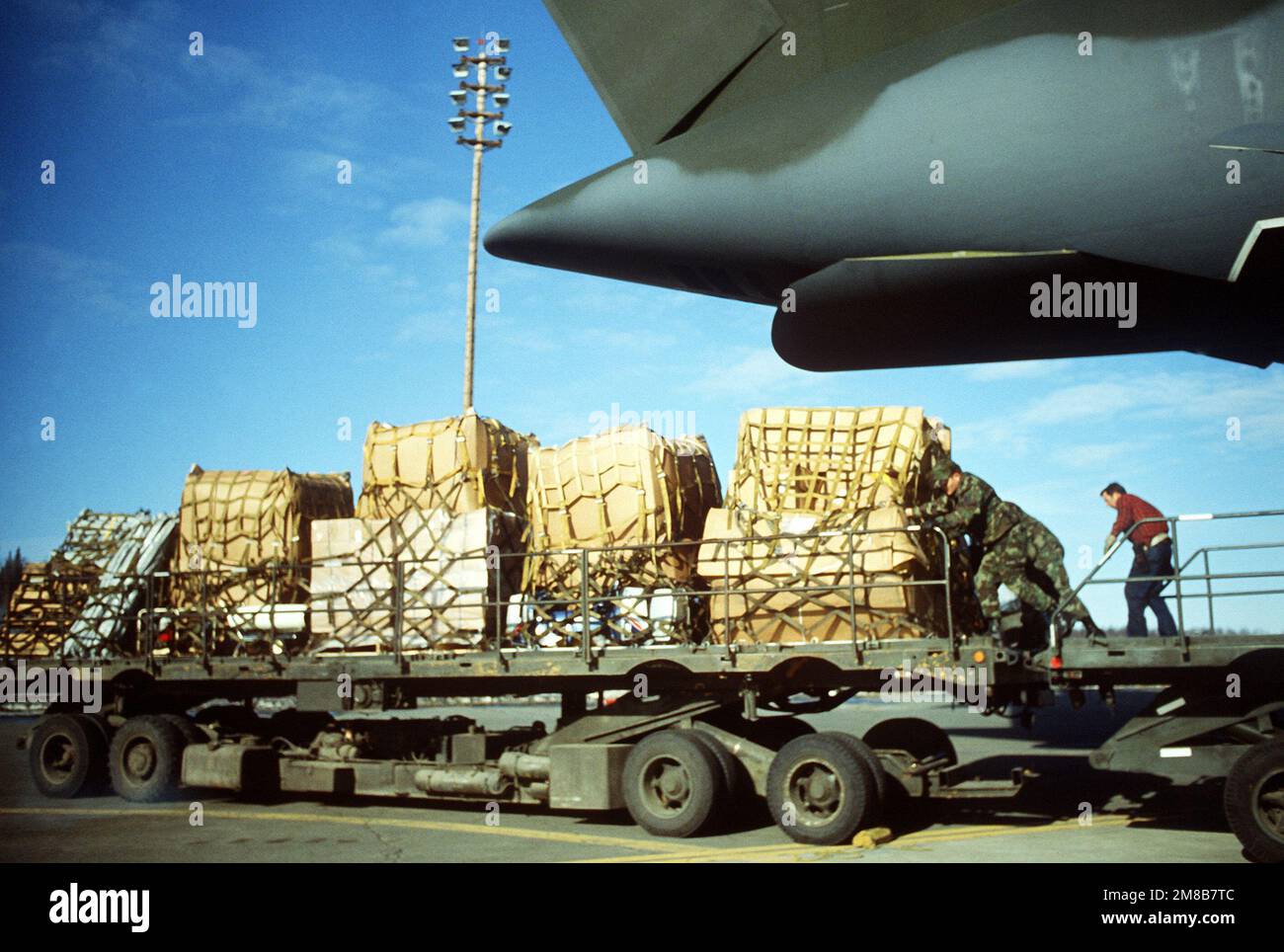 Members of the 616th Aerial Port Squadron push a pallet of equipment ...