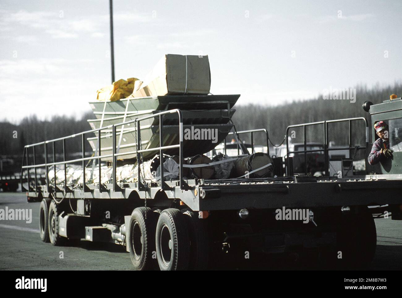 A civilian employee drives a K-loader along the flight line. On the ...