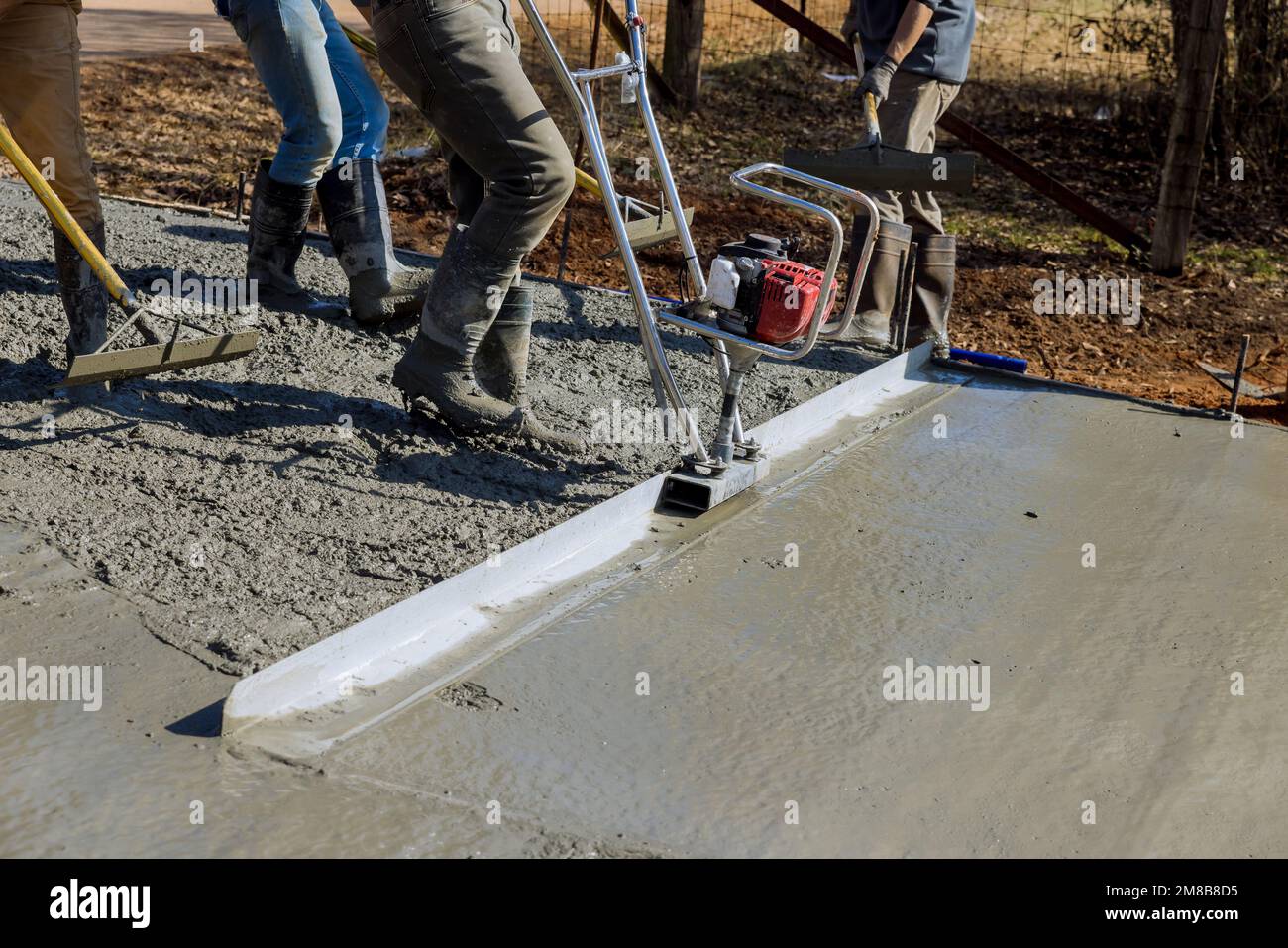 Machine is used in construction of new driveway to align new concrete ...