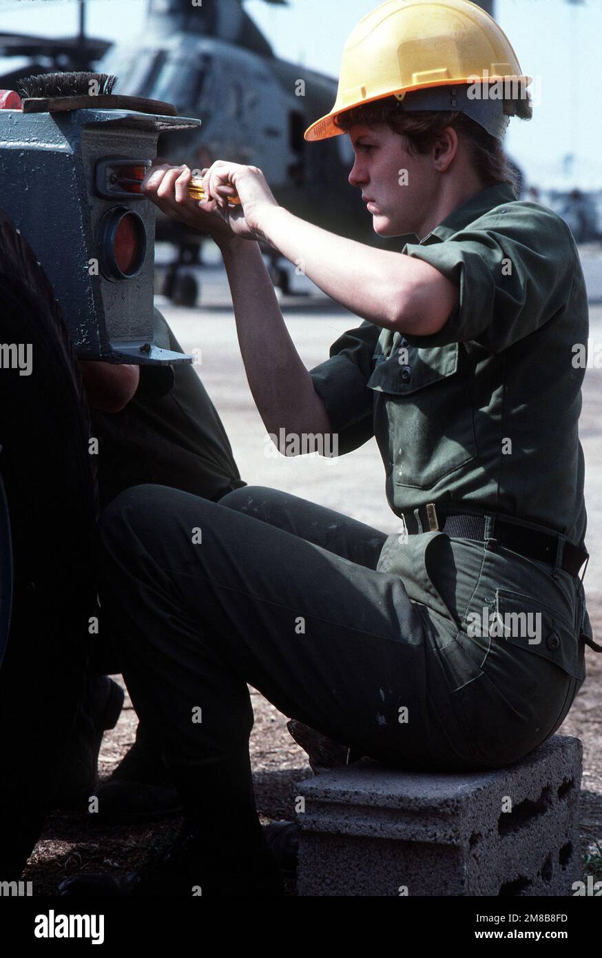 Equipment Operator 3rd Class Kim Cook of Naval Support Activity screws ...