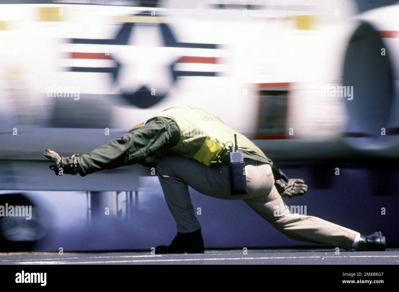 A member of the catapult crew gives the launch signal to an aircraft on ...