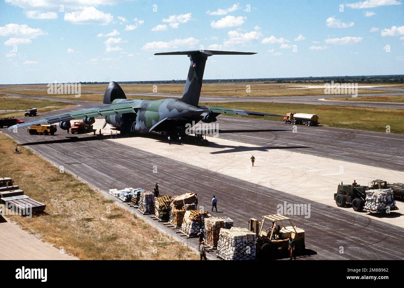 Pallets of supplies are offloaded from a Military Airlift Command C-5B ...