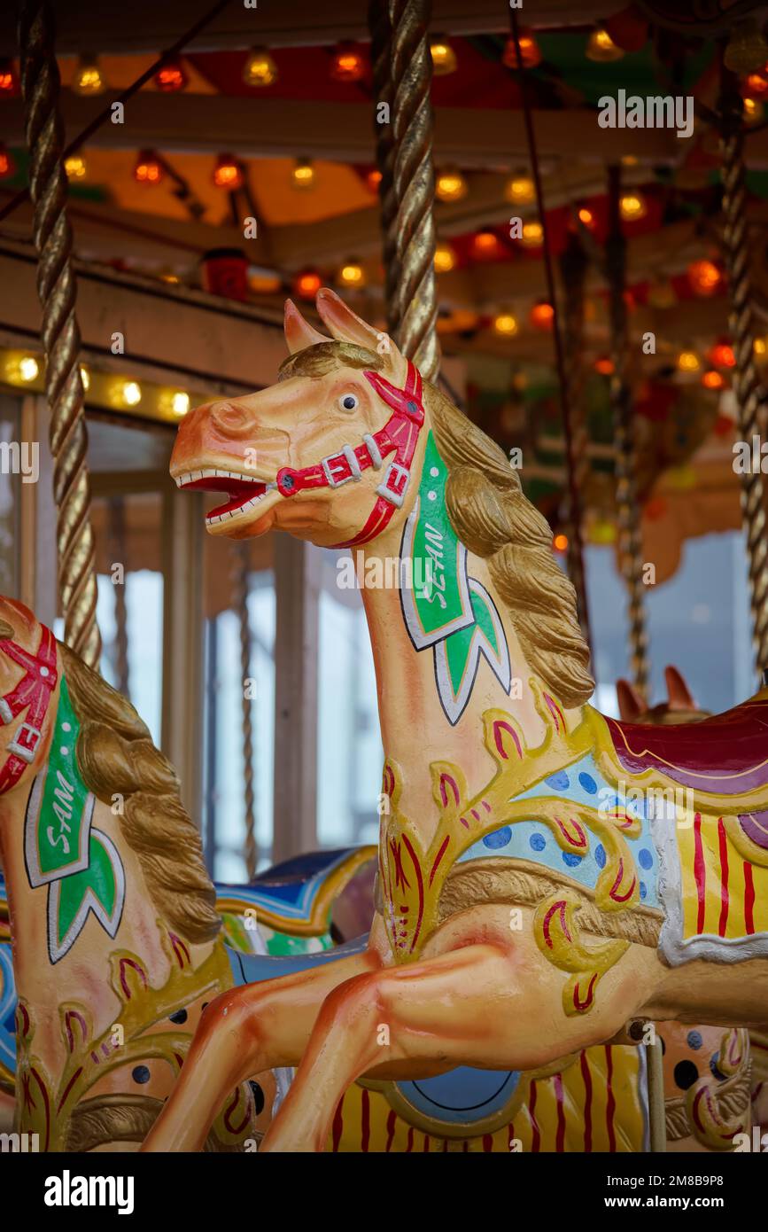 Vertical closeup photo of a colorful horse figure seat on vintage merry ...
