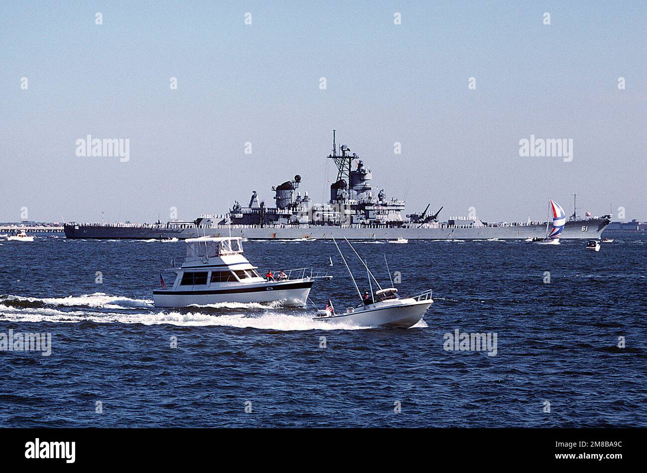 Numerous small craft surround the battleship USS IOWA (BB-61) as it ...