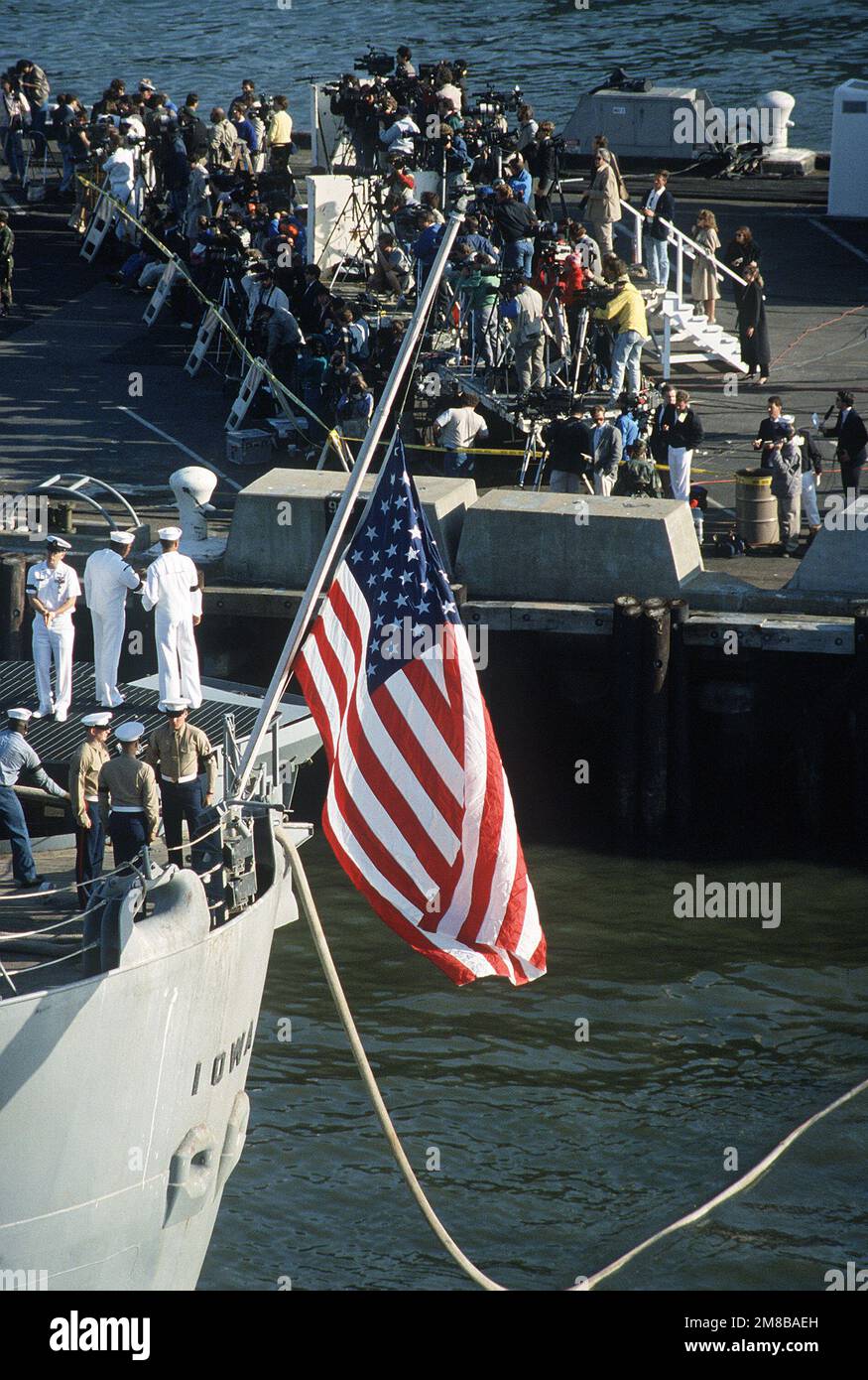 The American flag flies at half mast on the stern of the battleship USS ...