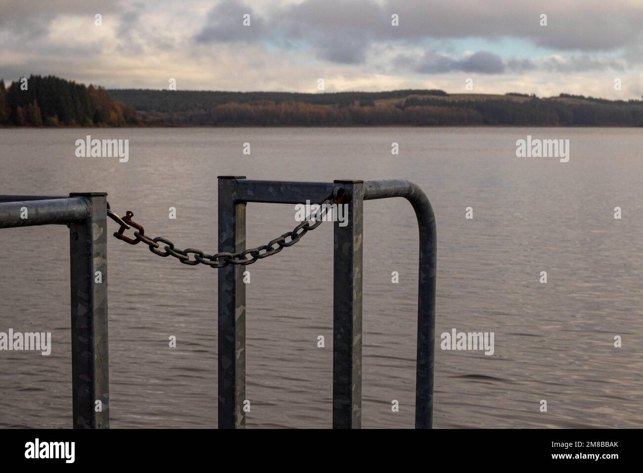 chain on jetty by lake cloudy day background Stock Photo - Alamy