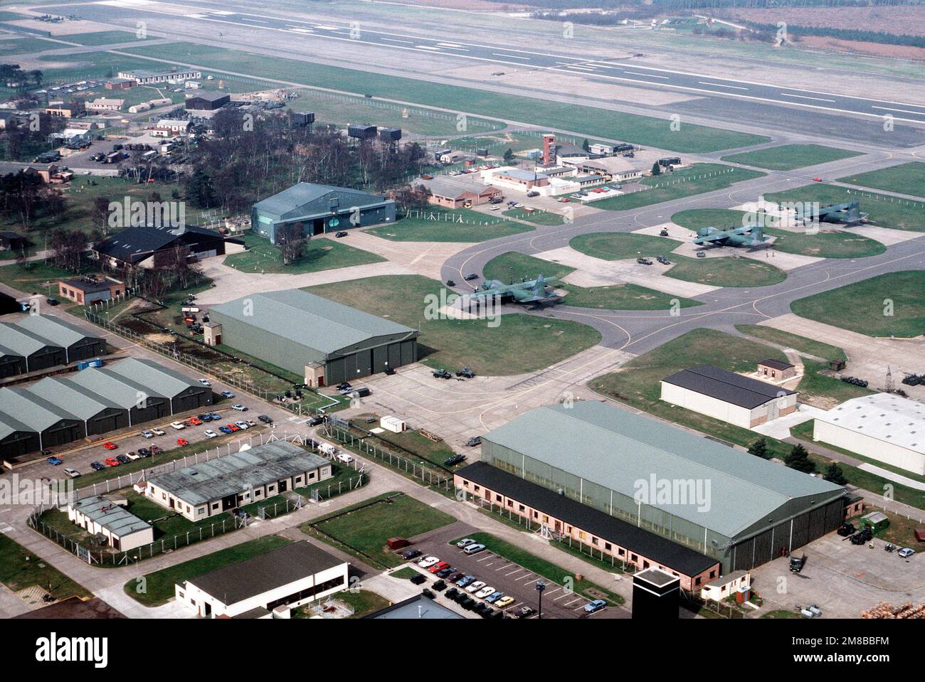 An aerial view of a hangar area and runway on the base, with several HC ...