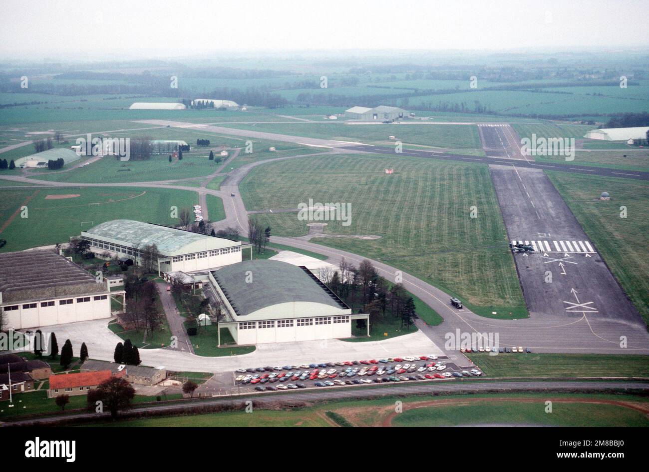 An aerial view of a runway and hangar area on the base. The Air Force ...