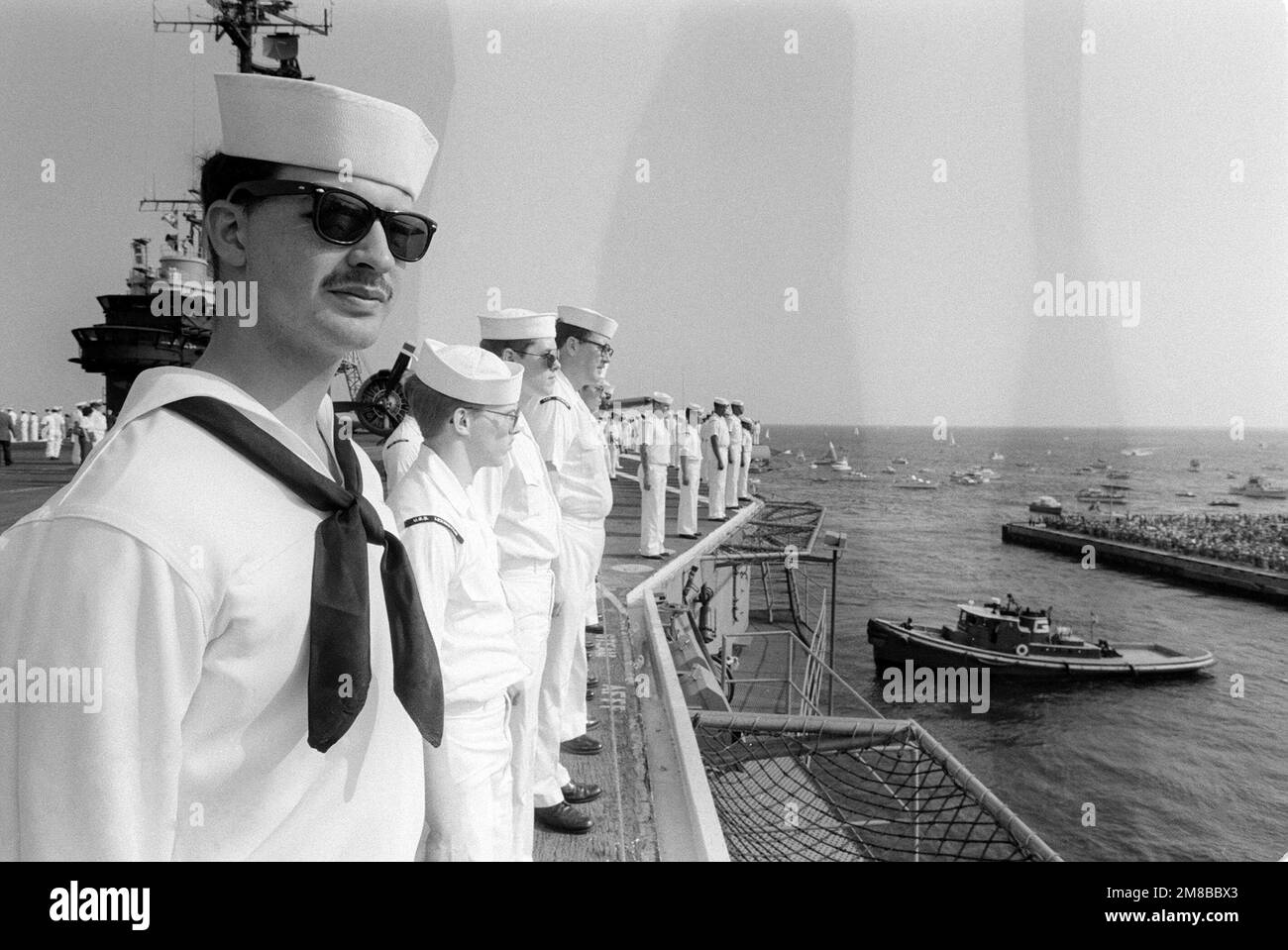 Crew members man the rails on the flight deck of the auxiliary aircraft ...